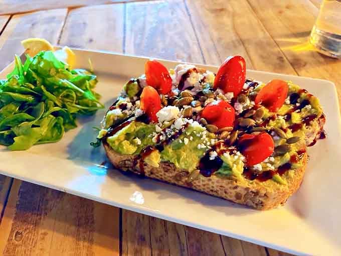 Avocado toast elevated to art form, complete with cherry tomatoes that actually taste like something and a balsamic drizzle.