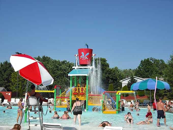 Red and white umbrellas dot the landscape like a cheerful checkerboard, providing shade for the strategically relaxed.