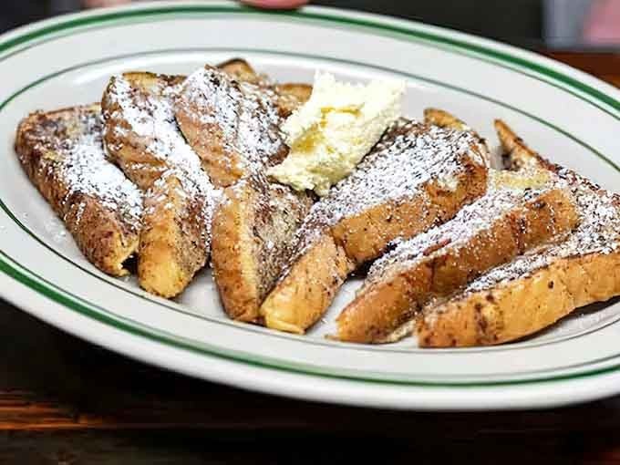 French toast dusted with powdered sugar like fresh snow on a delicious, golden mountain range.