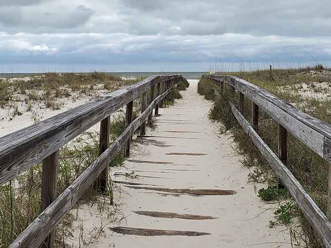 This weathered boardwalk leads straight to paradise, though the journey's half the fun with those dramatic skies.