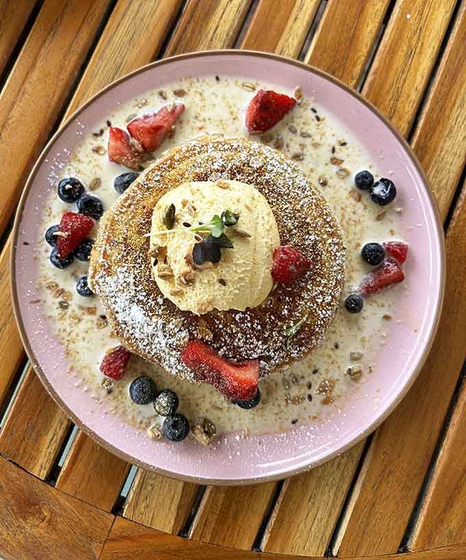 Tres Leches Pancakes dusted with powdered sugar and crowned with fresh berries, because sometimes breakfast needs a tiara.
