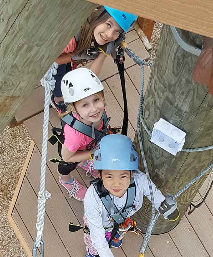 Three helmeted adventurers proving that courage comes in small packages, and apparently matching harnesses too.