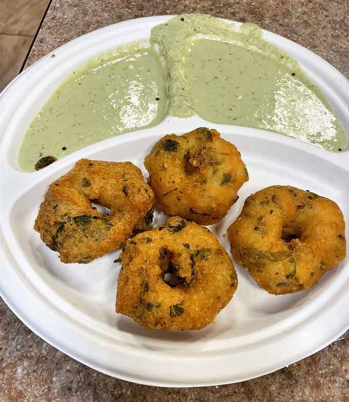 Savory lentil donuts swimming in coconut chutney prove that not all heroes wear capes, some wear golden-brown crusts instead.