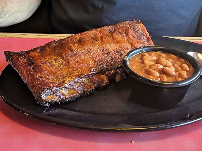 A full rack of mahogany-hued ribs next to sweet BBQ beans proves low and slow wins the race.