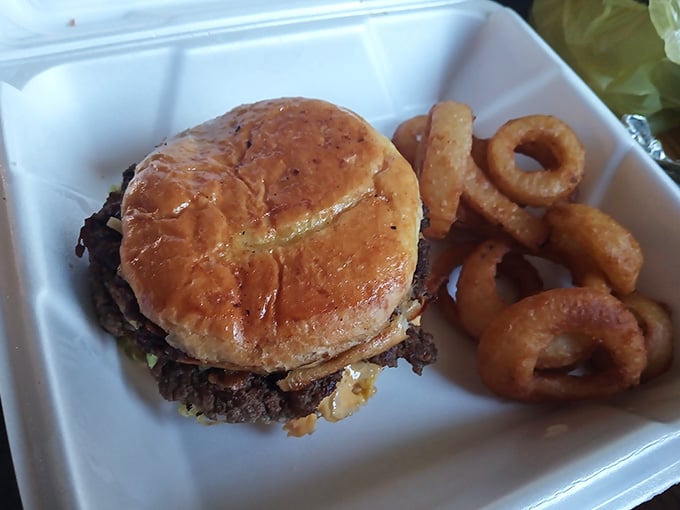 That homemade bun cradling a juicy burger with onion rings on the side is pure diner perfection.