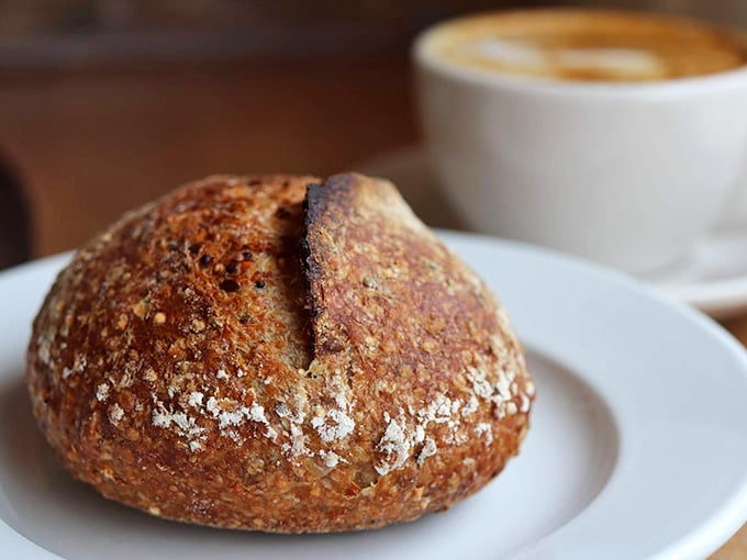 That crusty, flour-dusted sourdough boule sitting next to your latte is basically edible architecture at its finest.