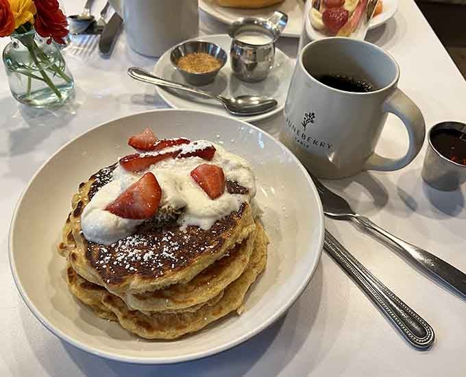 Fluffy pancakes topped with fresh strawberries and whipped cream, proving that simple done right beats fancy done wrong.
