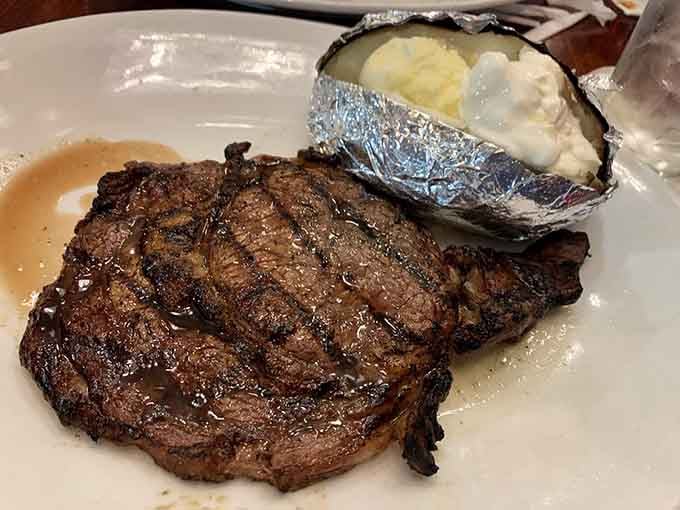 A ribeye this beautifully marbled paired with a loaded baked potato is basically the American dream on a plate.