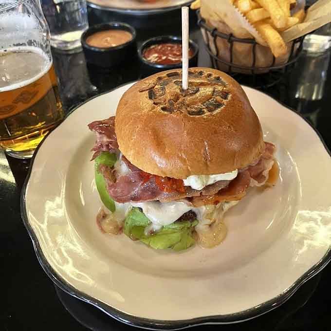 The Queens Rules Burger comes loaded with enough toppings to require a strategic eating plan and possibly a structural engineer's approval.
