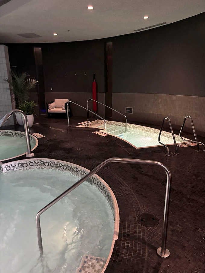 The moody lighting and curved pools create an atmosphere that whispers "relax" in every language.