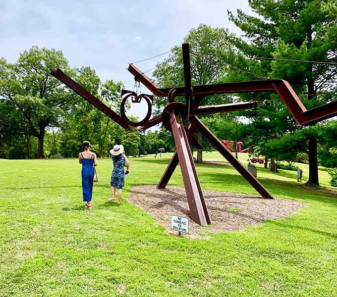 Two visitors contemplate whether this sculpture is profound art or the world's most interesting jungle gym debate.