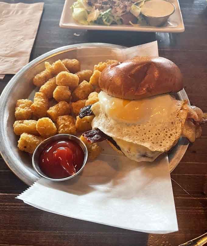 A burger with a fried egg and tater tots isn't playing around&mdash;this is serious business disguised as casual dining.