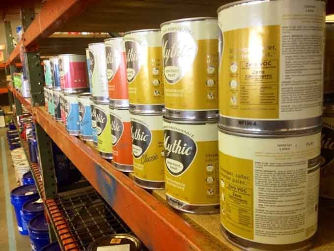 Paint cans organized like a rainbow, ready to transform your boring beige walls into something worth photographing.