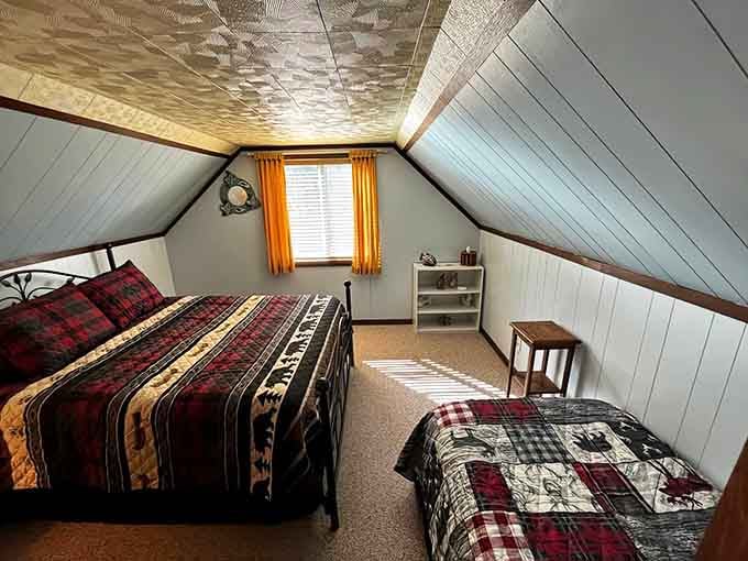 The loft bedroom with its cozy quilts and slanted ceiling feels like a nostalgic hug from summer camp.