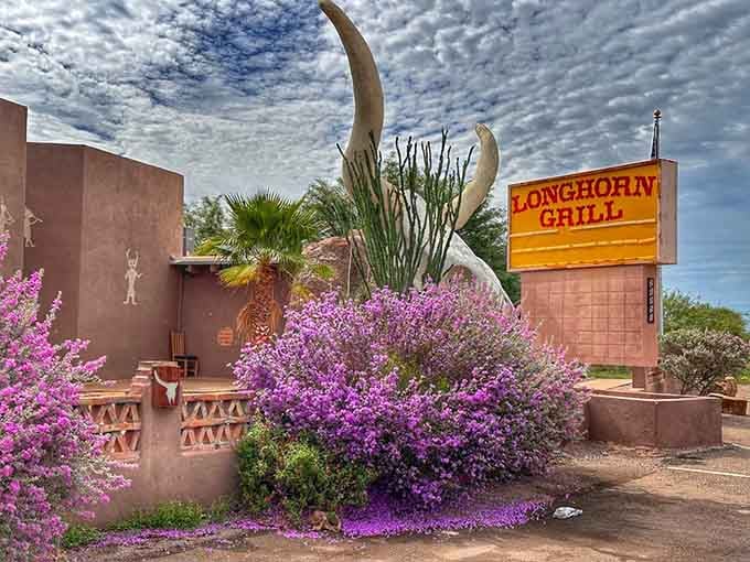 Purple blooms frame the entrance like nature decided to accessorize this already spectacular roadside attraction perfectly.