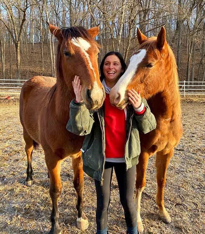 Nothing says "living your best life" quite like being sandwiched between two gorgeous horses who clearly adore you.