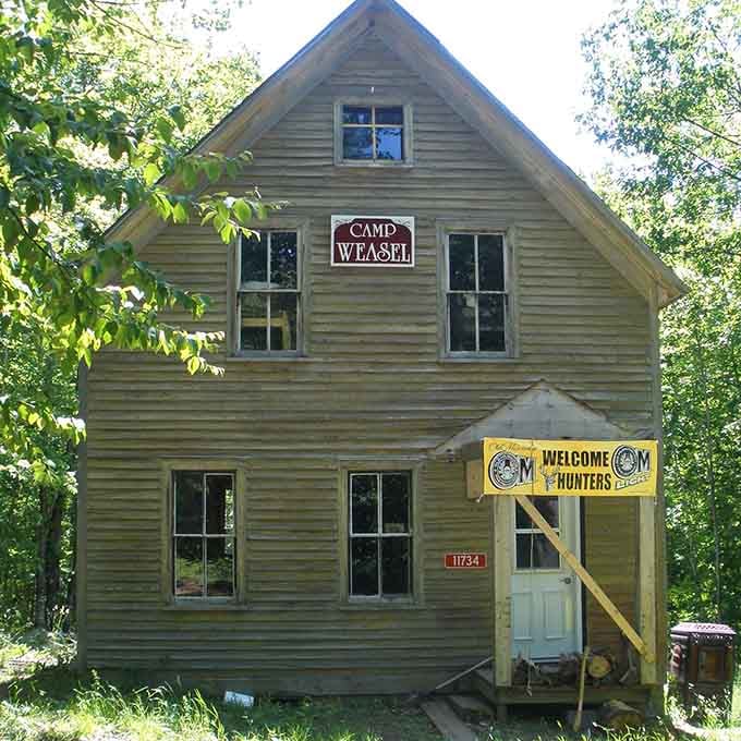 Camp Weasel welcomes hunters to what remains of civilization, proving optimism survives even when towns don't make it.