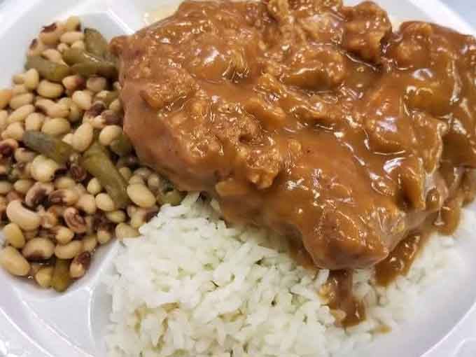 Smothered pork chops swimming in gravy over rice is the definition of Southern hospitality on a plate.