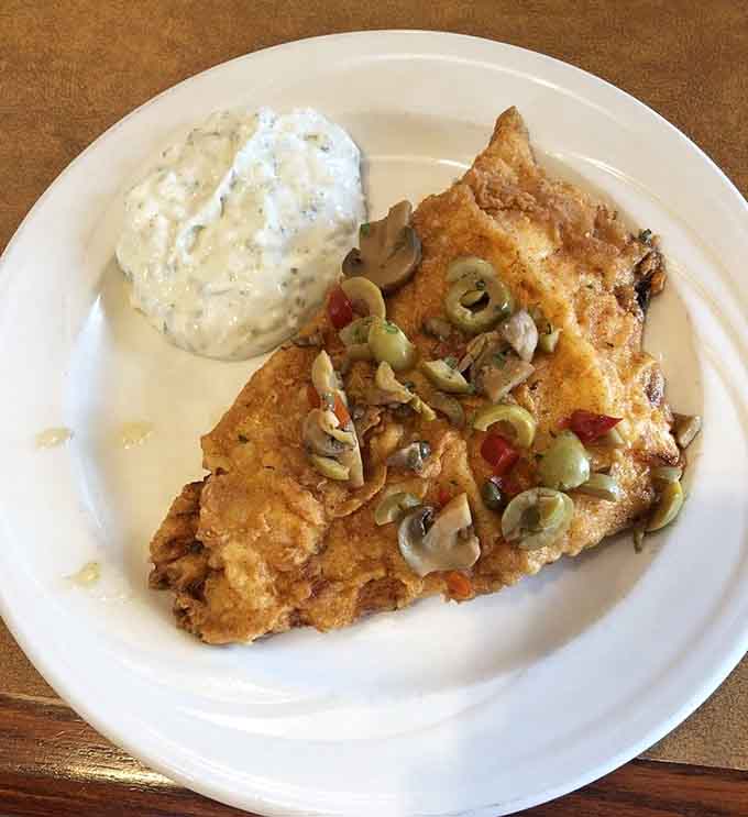 Baked scrod topped with vegetables shows that cafeteria food can be both comforting and surprisingly sophisticated.