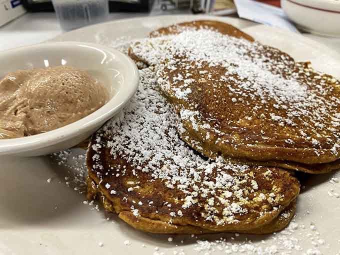 Pumpkin pancakes dusted with powdered sugar and that little cup of mystery sauce spell autumn bliss.