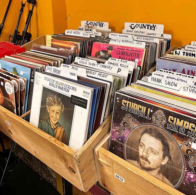 Country legends peer out from wooden crates, waiting patiently for someone who remembers when music told real stories.