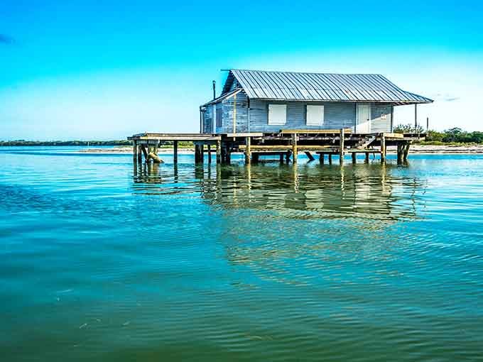 A weathered structure stands over turquoise waters, looking like it wandered off a postcard and decided to stay.