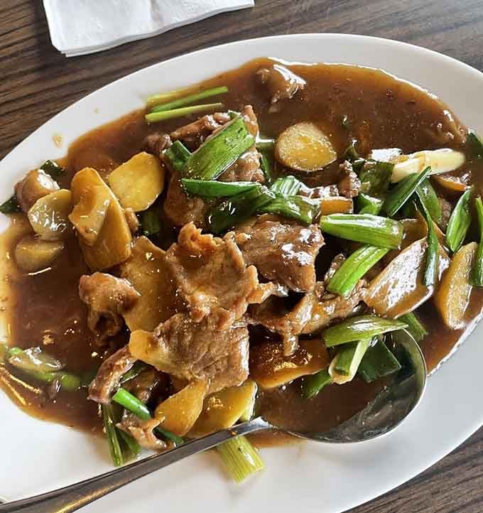 Tender beef swimming in ginger and scallions delivers the kind of comfort that makes you forget you're dining on rails.