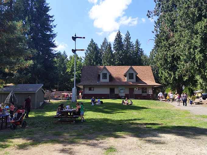 A charming building with dormer windows overlooks the grounds where visitors spread blankets and enjoy Oregon sunshine.