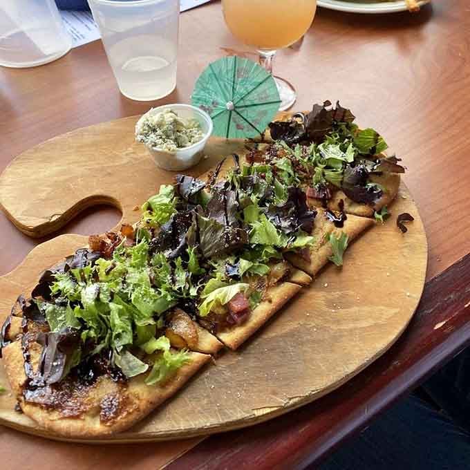 Prosciutto flatbread served on a wooden board, because even pizza deserves to feel fancy once in a while.