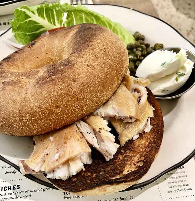 Smoked trout on a bagel with capers and cream cheese brings sophisticated brunch vibes to classic diner charm.