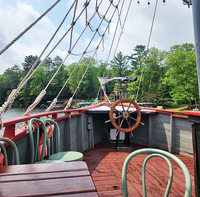 The ship's wheel stands ready for your command, with rigging overhead and endless lake views stretching toward the horizon.