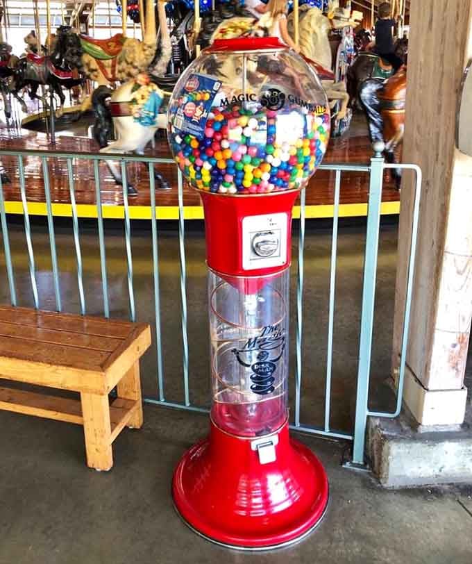 A vintage gumball machine taller than most kids stands ready to dispense rainbow-colored joy for pocket change.