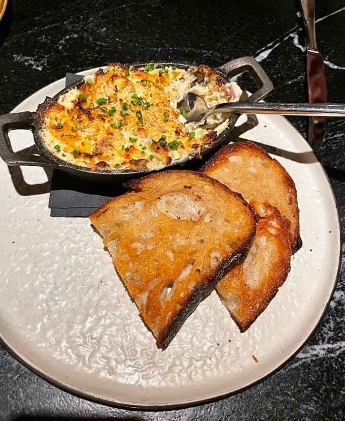 That golden, bubbling crab dip with toasted bread is basically edible treasure from the deep.