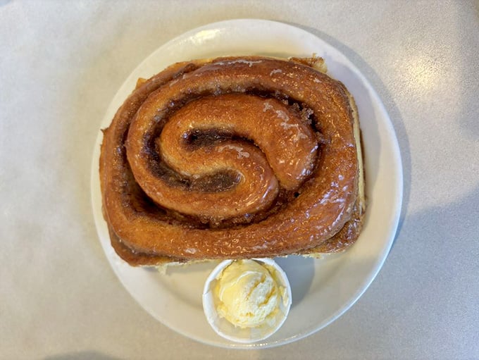 This isn't just a cinnamon roll; it's a plate-sized monument to the power of butter, sugar, and unwavering commitment.