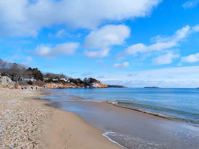 Gentle waves lap the shore under cotton candy clouds, creating the kind of scene that makes calendars jealous.