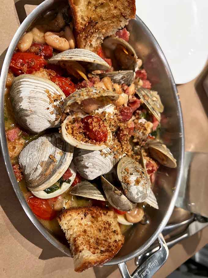 Clams, beans, and tomatoes in perfect harmony, proving that sometimes the best relationships involve seafood and carbs in a pan.