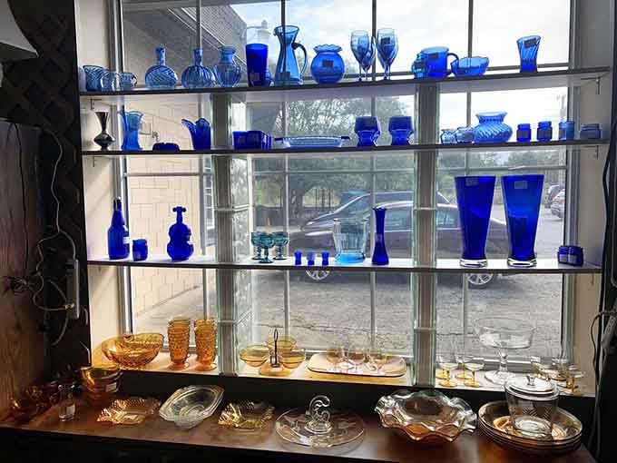 Cobalt blue glassware catches the light like sapphires, turning a simple window display into pure art.