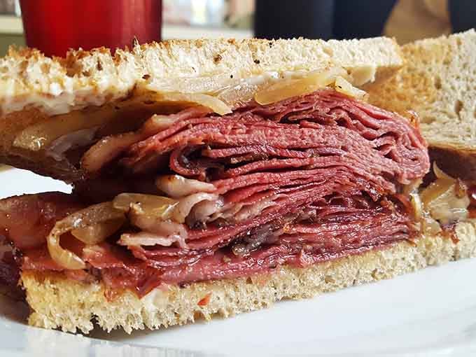 Look at that glorious stack of pastrami towering between bread like a skyscraper of pure flavor happiness.