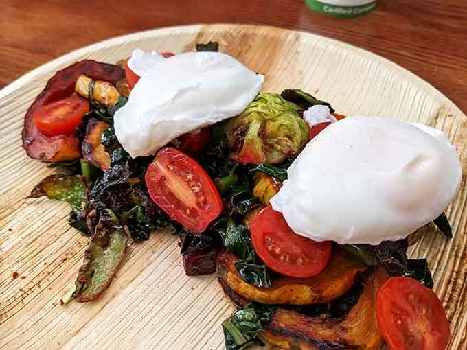 Poached eggs perched atop roasted vegetables like they're surveying their delicious kingdom of seasonal goodness below.