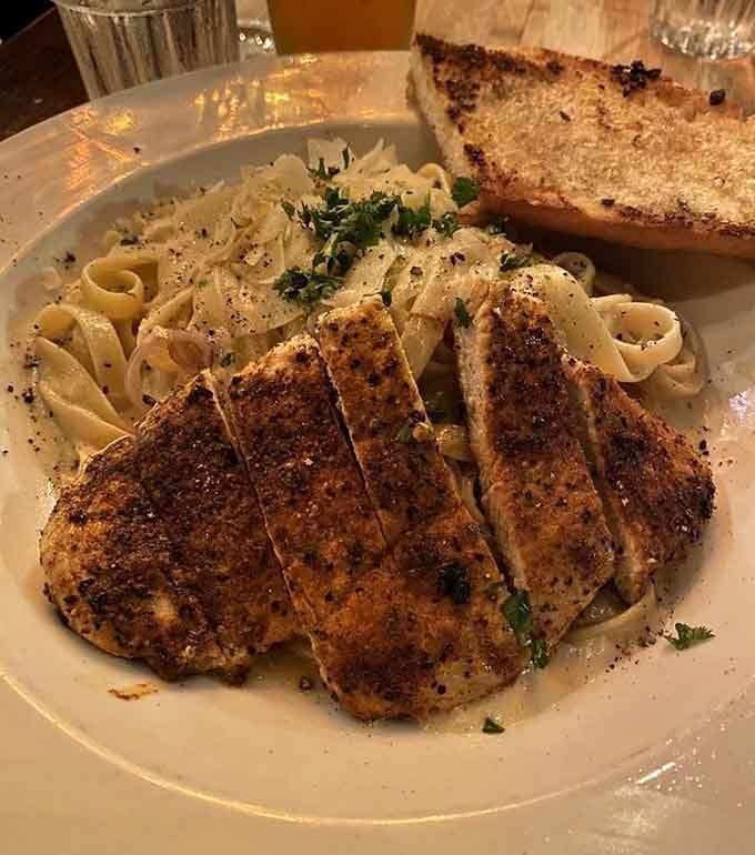 Blackened chicken over fettuccine alfredo with garlic bread proves sometimes you need backup for your backup carbs.