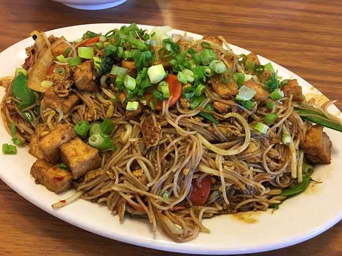 Singapore noodles piled high with vegetables and protein, proving that "too much of a good thing" is a myth.