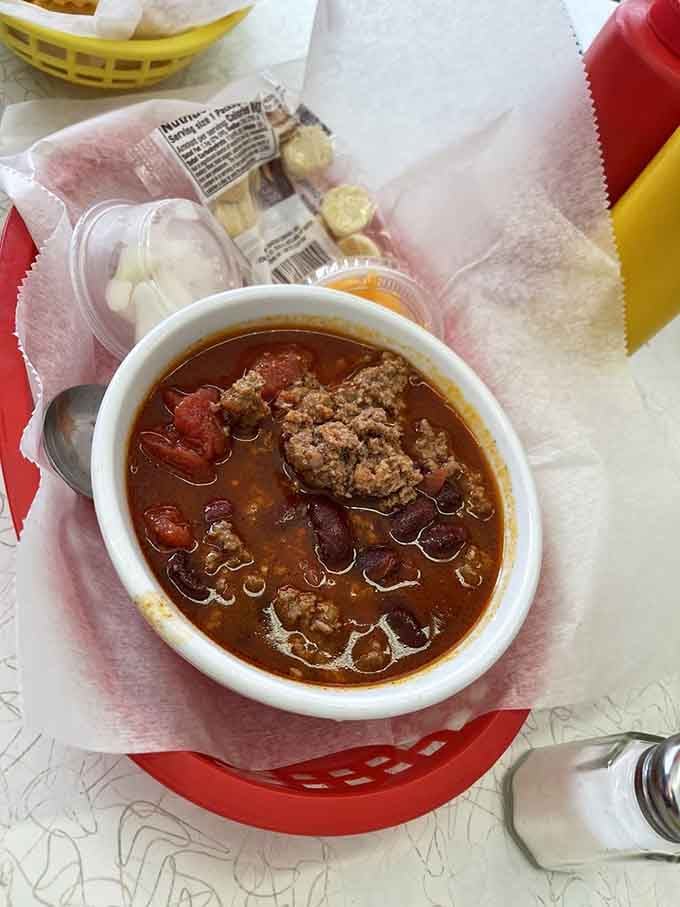 Homemade chili with crackers and onions on the side, comfort in a bowl that warms you like a hug.