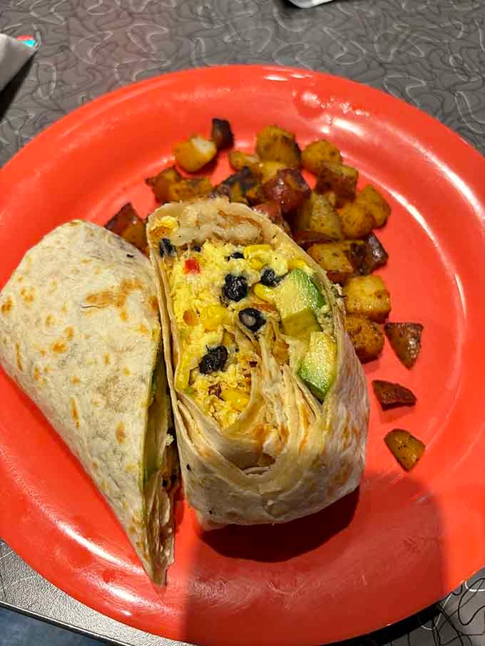 That perfectly grilled tortilla holds together scrambled eggs, black beans, and avocado like edible architecture at work.