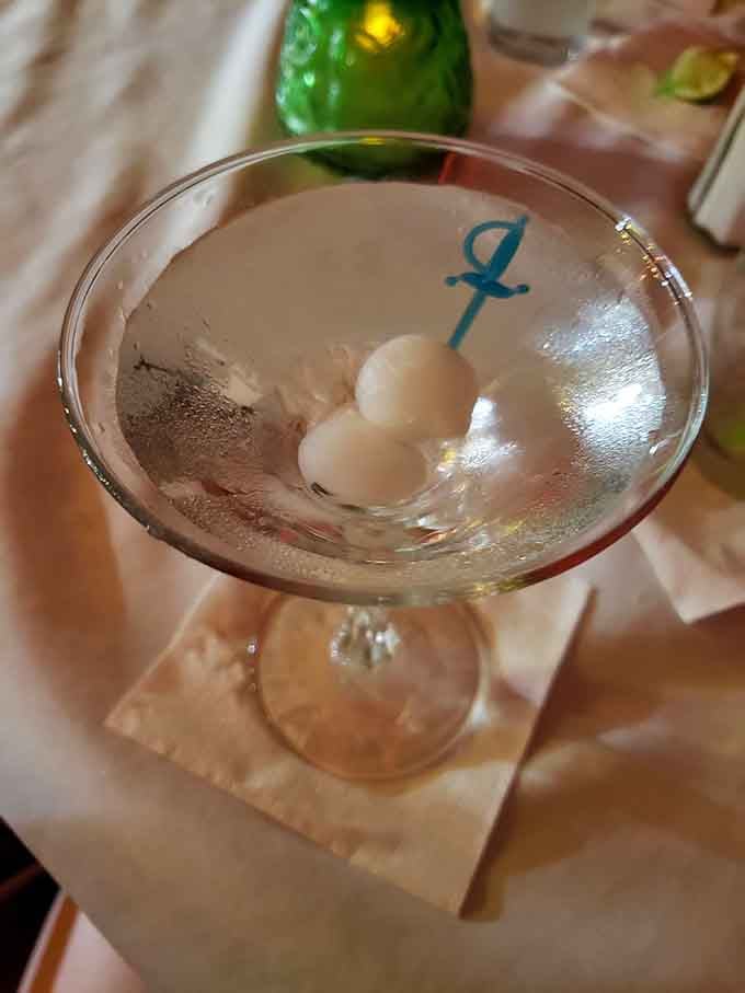 Gibson martini with those iconic pickled onions, served in glassware that's seen better conversations than your therapist.