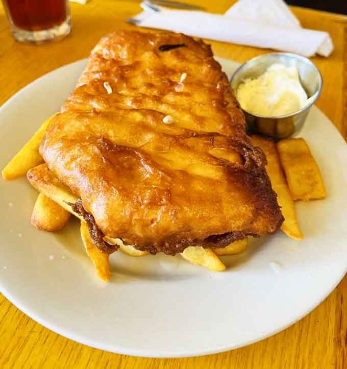 Fish and chips done right: crispy batter protecting tender cod like edible bubble wrap with flavor.