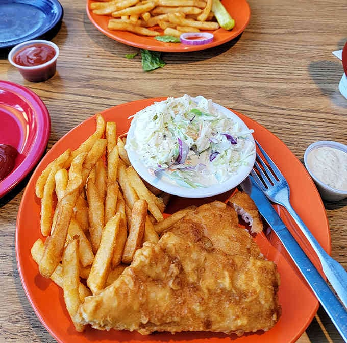 That beer batter shatters like glass, revealing tender fish beneath a mountain of creamy coleslaw perfection.