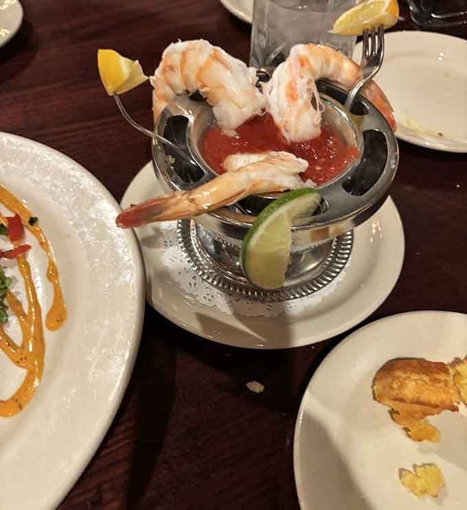 Jumbo shrimp perched elegantly in their silver chalice, ready to dive into tangy cocktail sauce like synchronized swimmers.