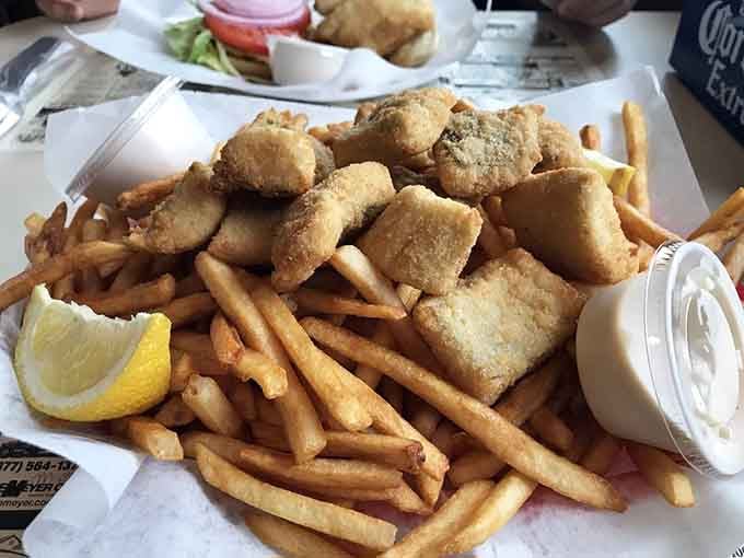 Behold: generous walleye fillets atop a mountain of fries, the kind of plate that makes diets take vacations.