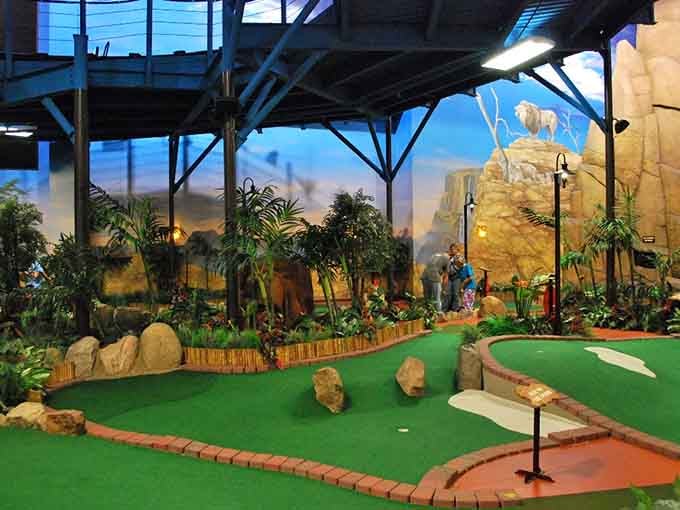 Mini golf with a safari theme and painted skies overhead, proving that imagination doesn't need sunshine to thrive indoors.