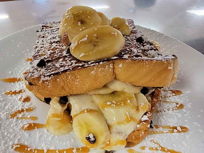 French toast dressed up fancy with bananas and chocolate drizzle proves breakfast can absolutely be an art form here.